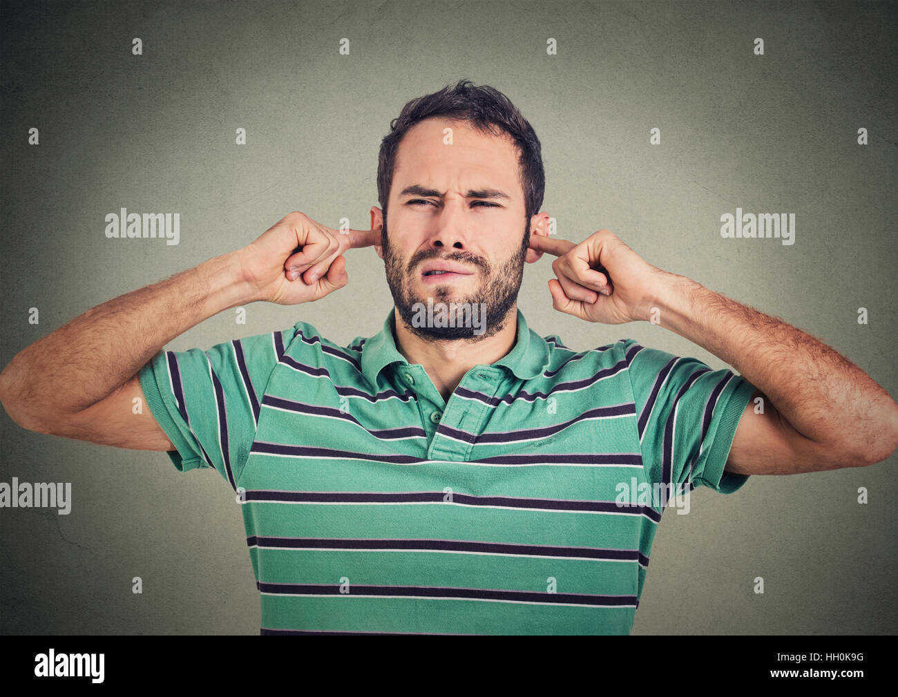 headshot displeased man plugging ears with fingers doesn't want to ...