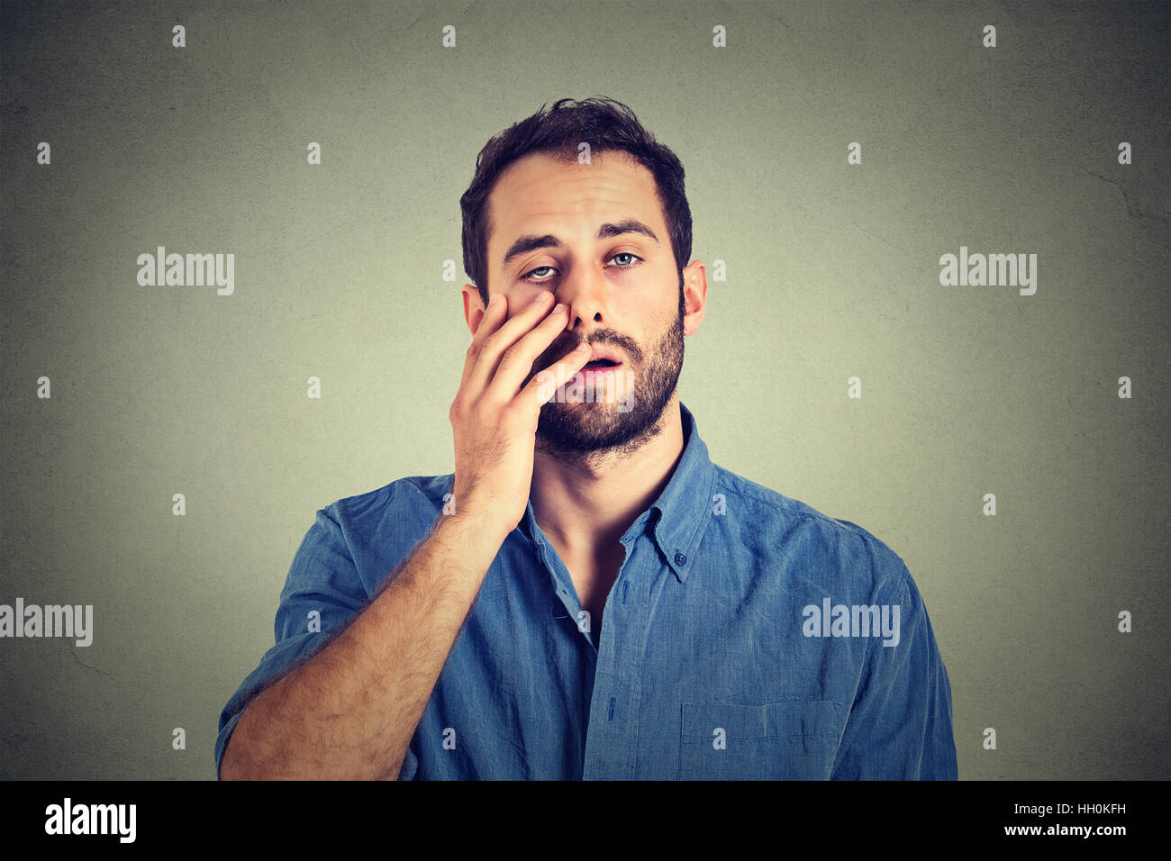 Tired man. Groggy sad, depressed guy with a headache isolated on gray ...