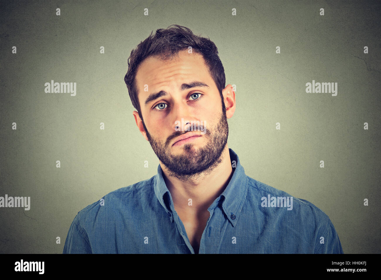 Portrait of a sad young man isolated on gray wall background Stock ...