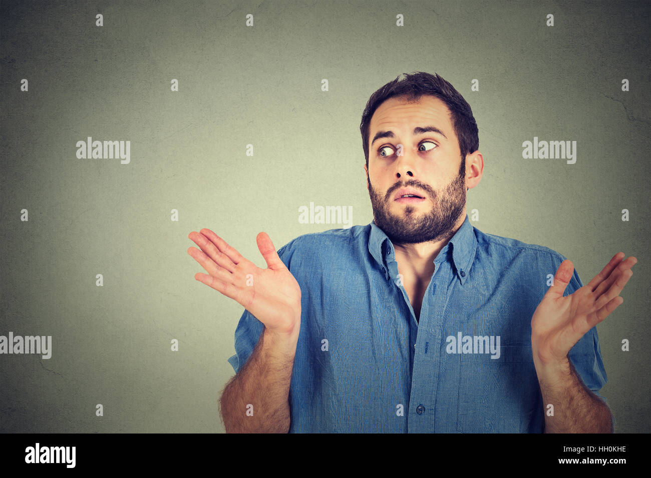 Closeup portrait young man shrugging shoulders who cares so what I don ...