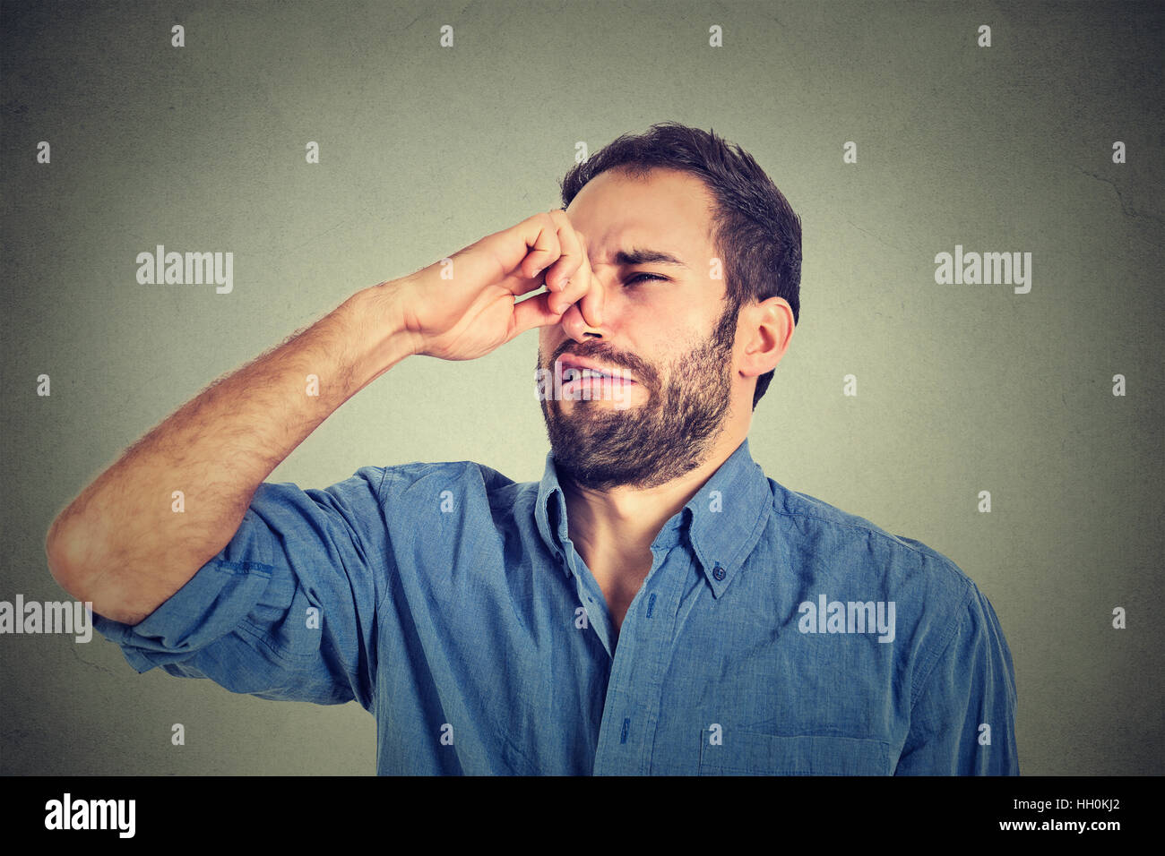 disgusted man pinches nose with fingers looks with disgust something ...