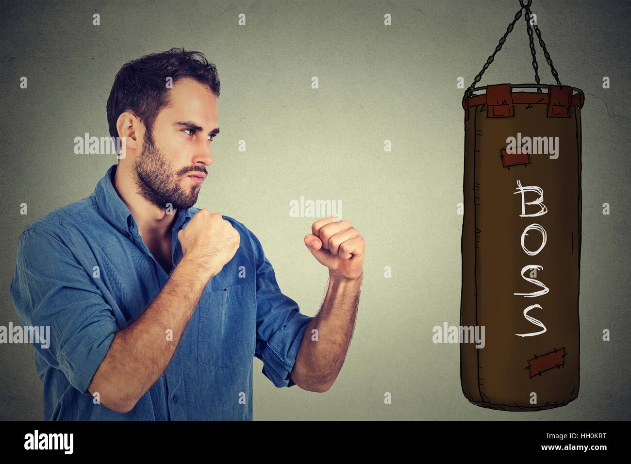 man ready to punch boxing bag with word boss written on it. negative ...