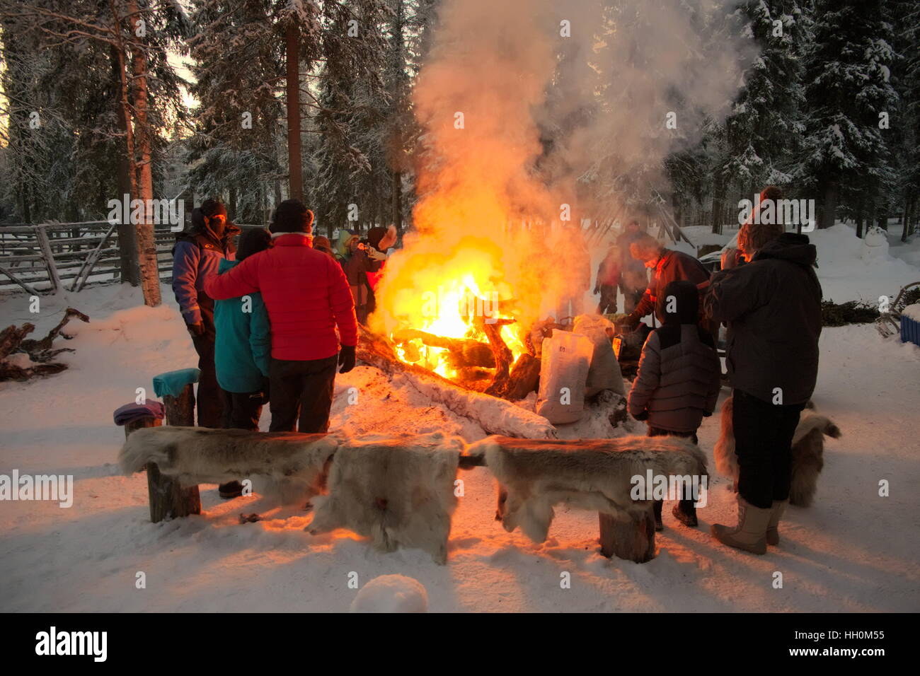 Warming up by the fire after enjoying a Reindeer safari Stock Photo - Alamy