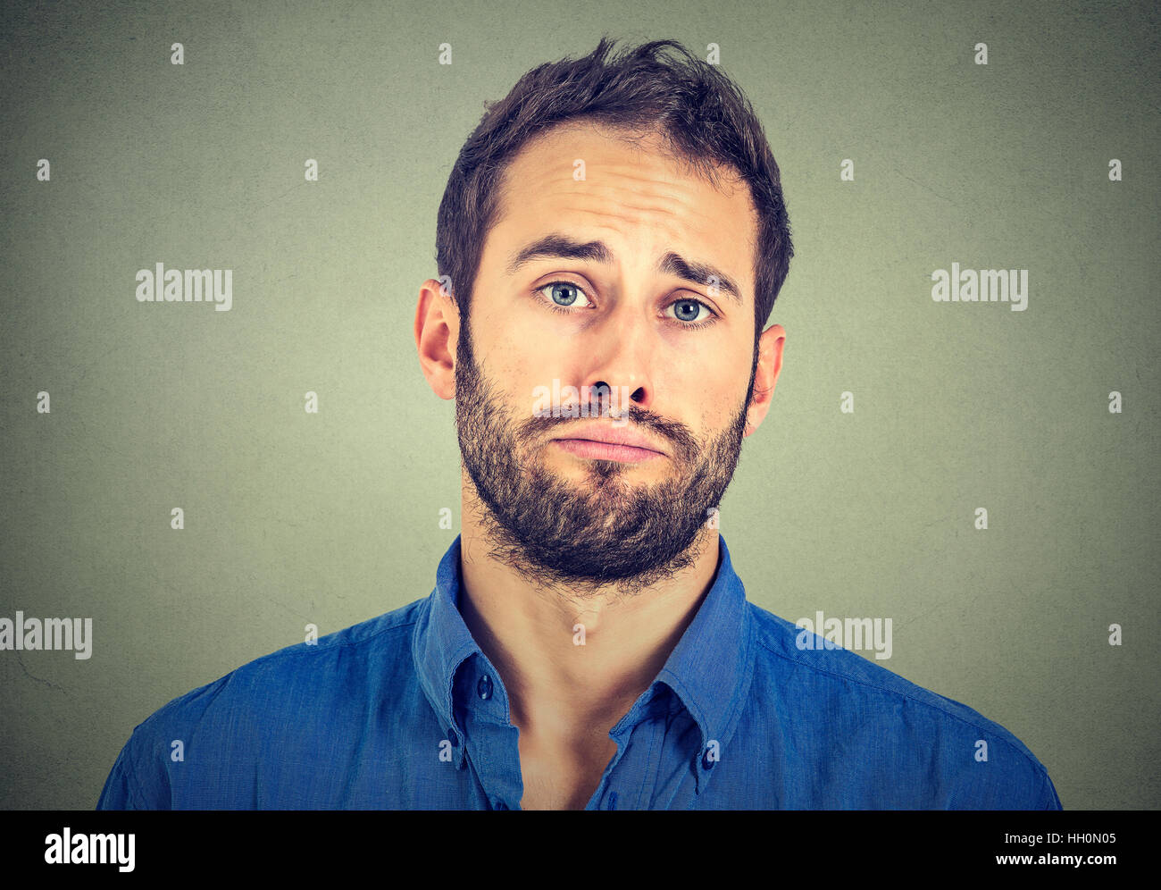 portrait of sad young man isolated on gray wall background Stock Photo ...