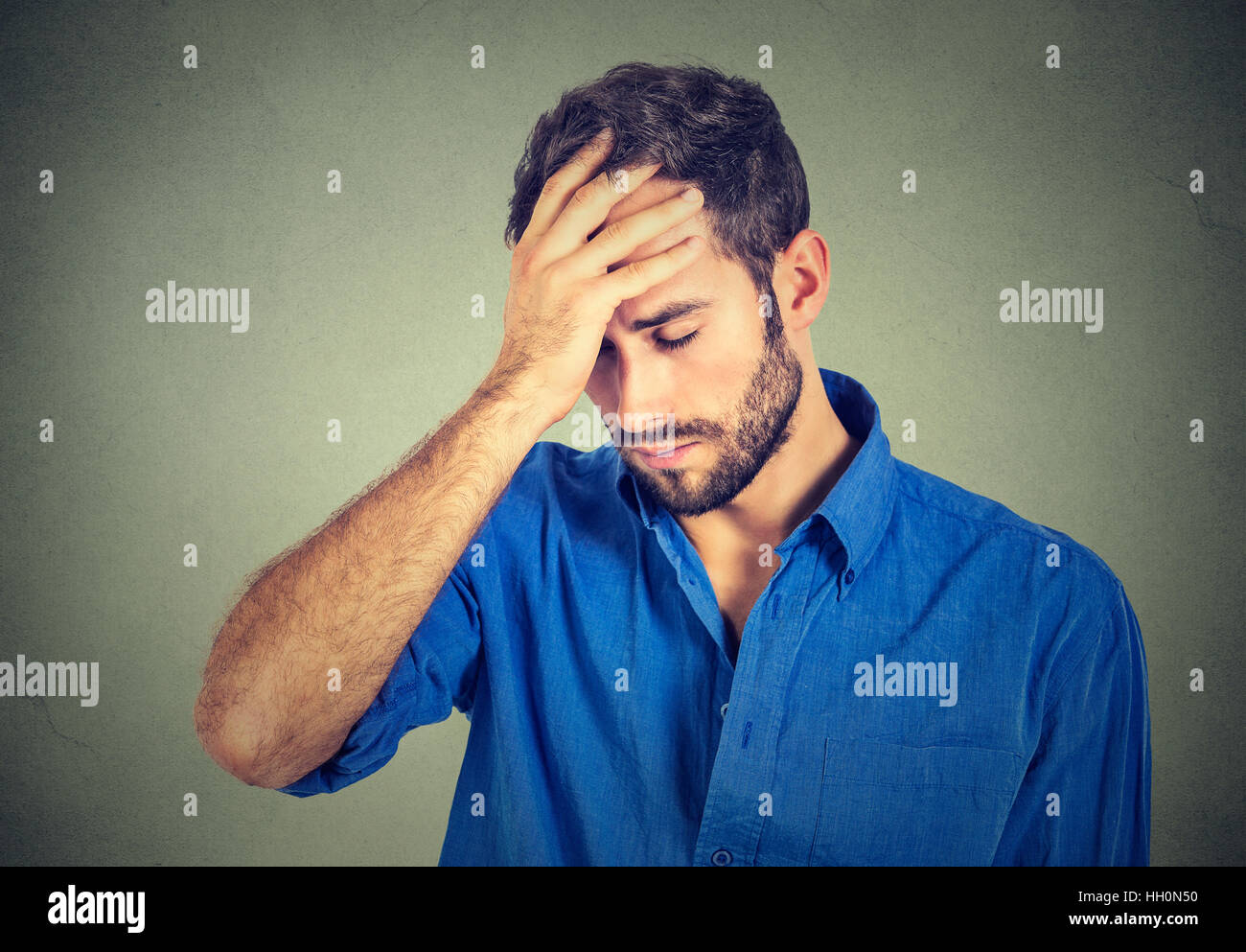 portrait stressed sad young man looking down isolated on gray wall ...