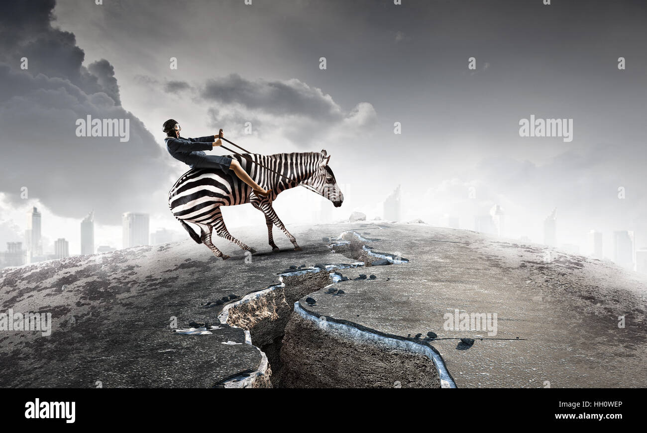 Young pretty fearless woman riding zebra animal Stock Photo - Alamy