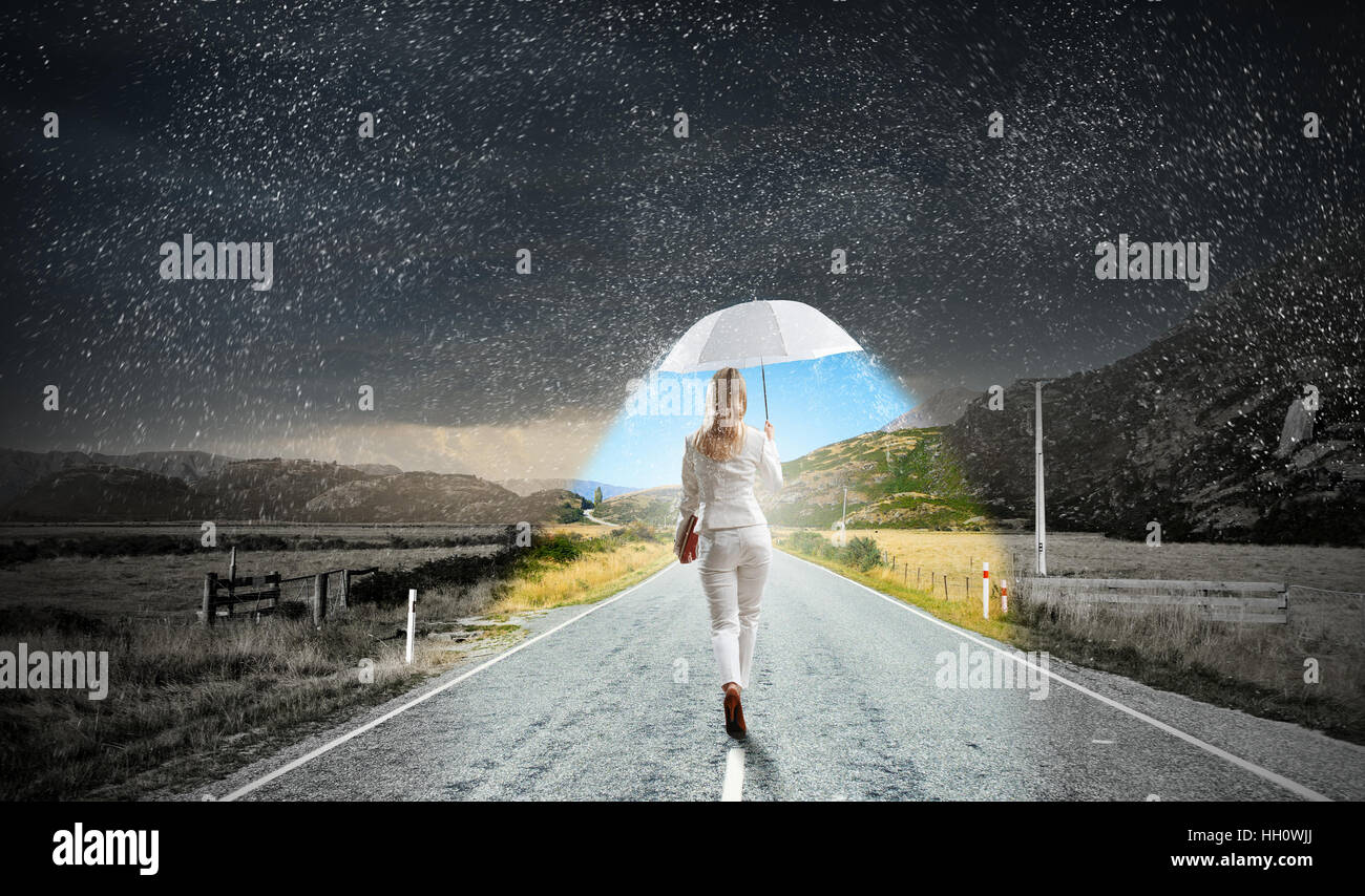 Elegant businesswoman hiding from rain under umbrella Stock Photo - Alamy