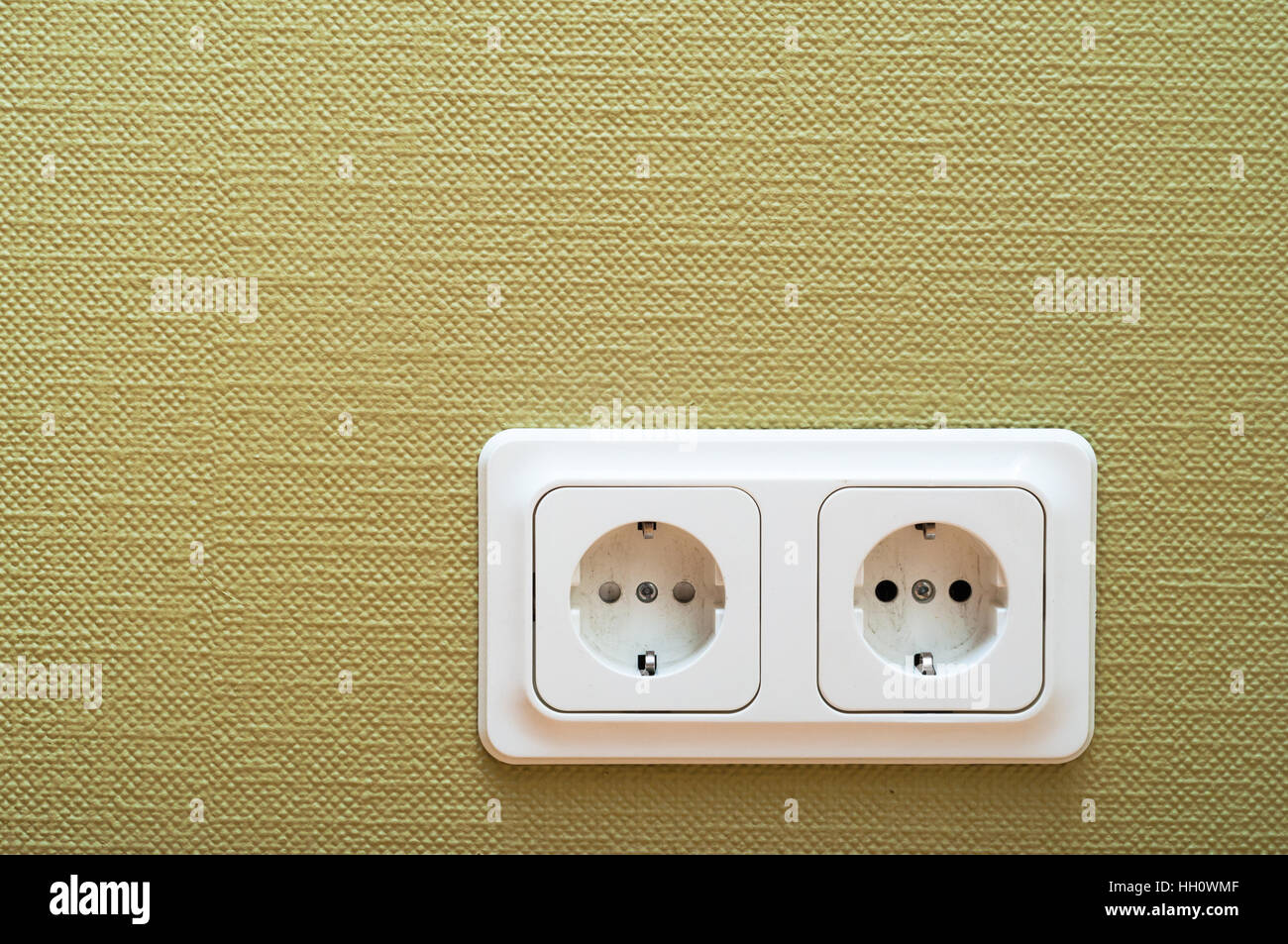 White dual socket on green wall Stock Photo - Alamy