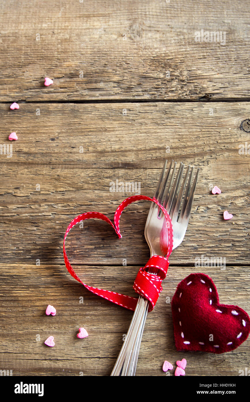 Table setting (two forks) for Valentine's Day with red hearts on rustic ...