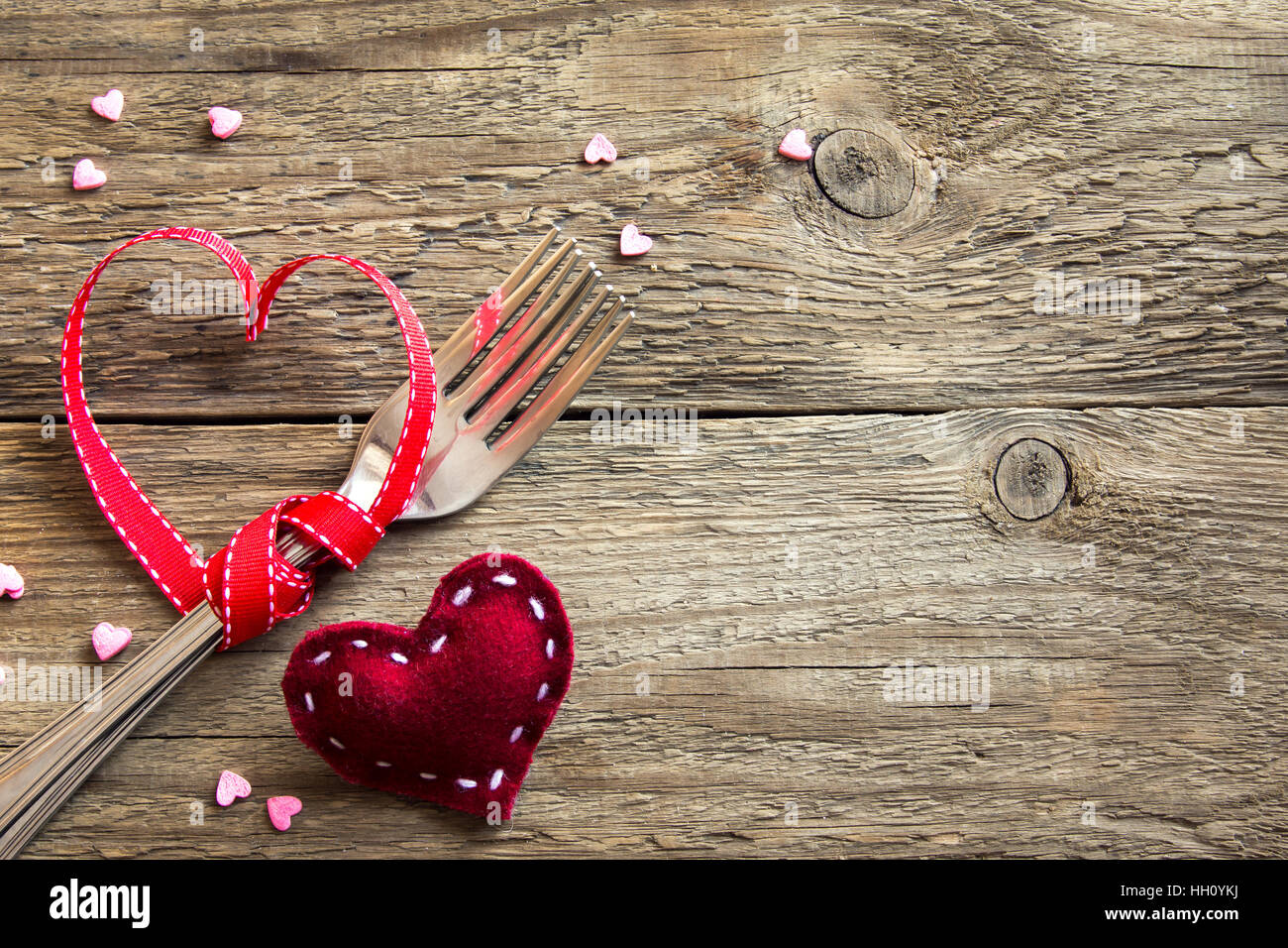 Table setting (two forks) for Valentine's Day with red hearts on rustic ...