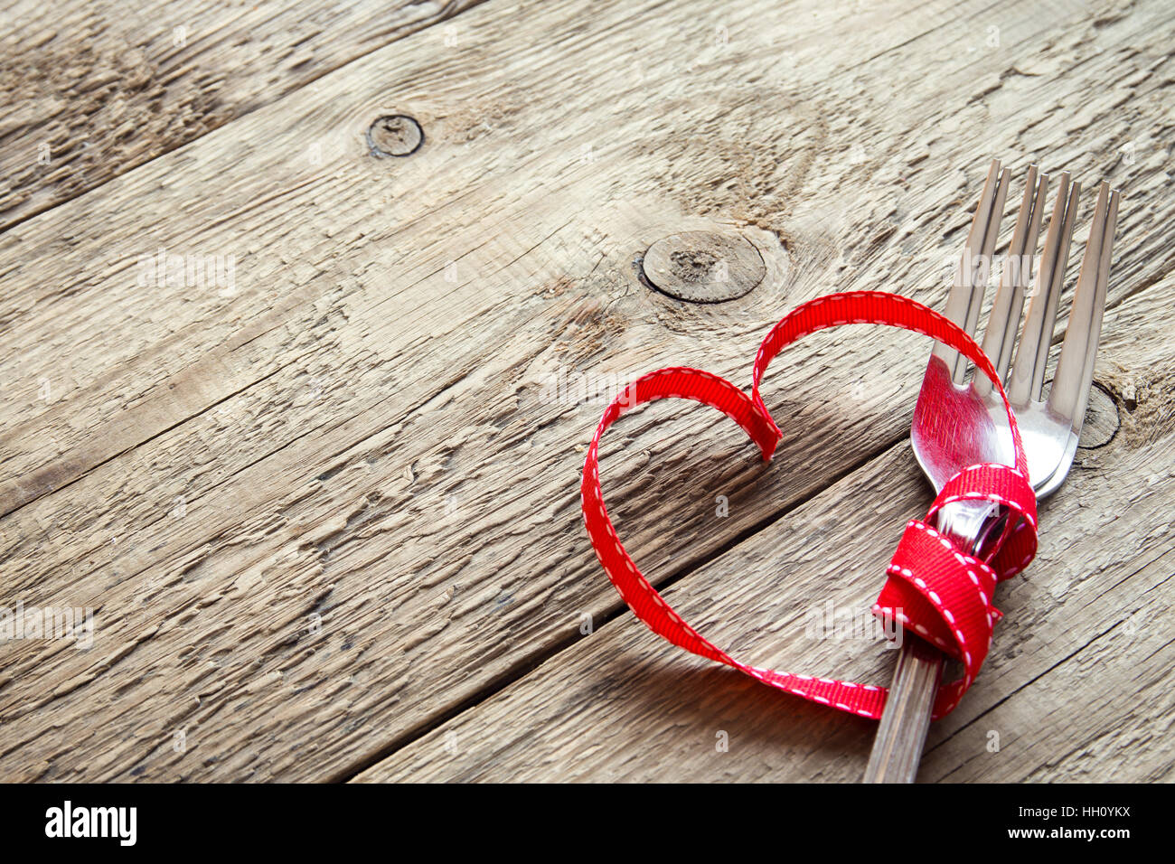 Table setting (two forks) for Valentine's Day with red hearts on rustic ...