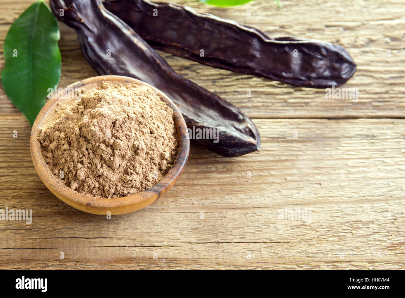 Carob pods and carob powder over wooden background with copy space ...