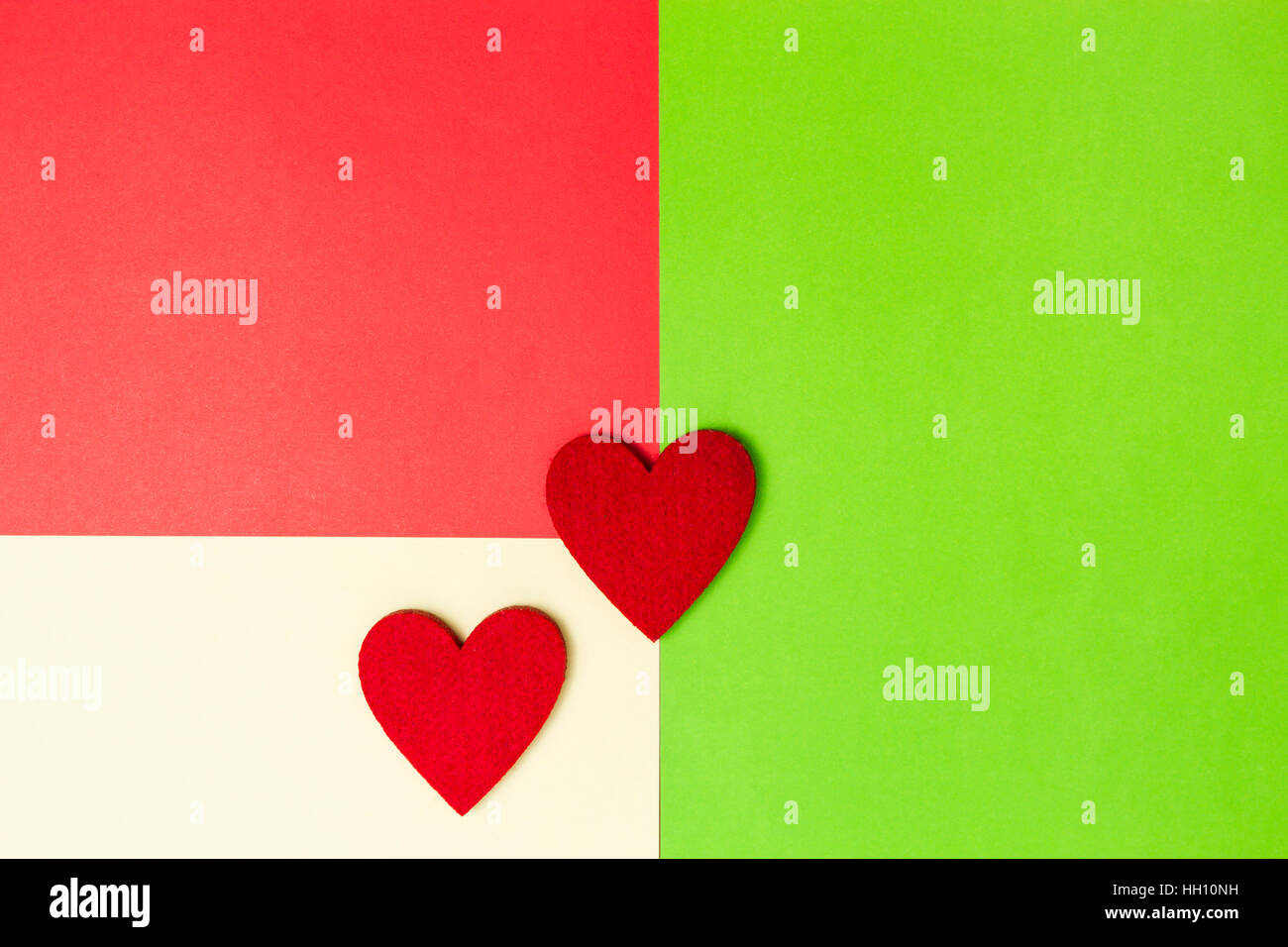 Two hearts on greenery, red and yellow colored paper background. Top ...