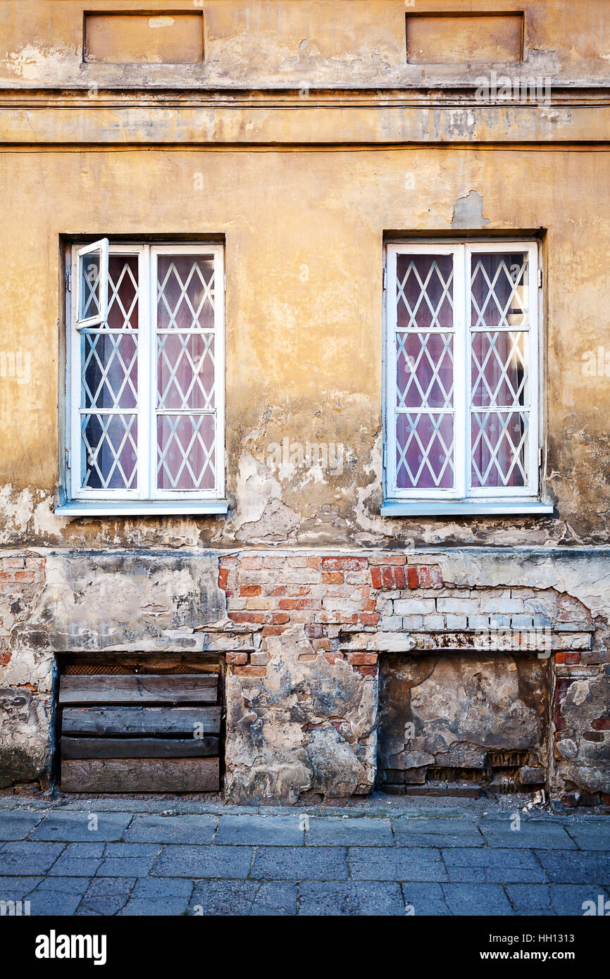 Aged weathered street wall with some windows Stock Photo - Alamy