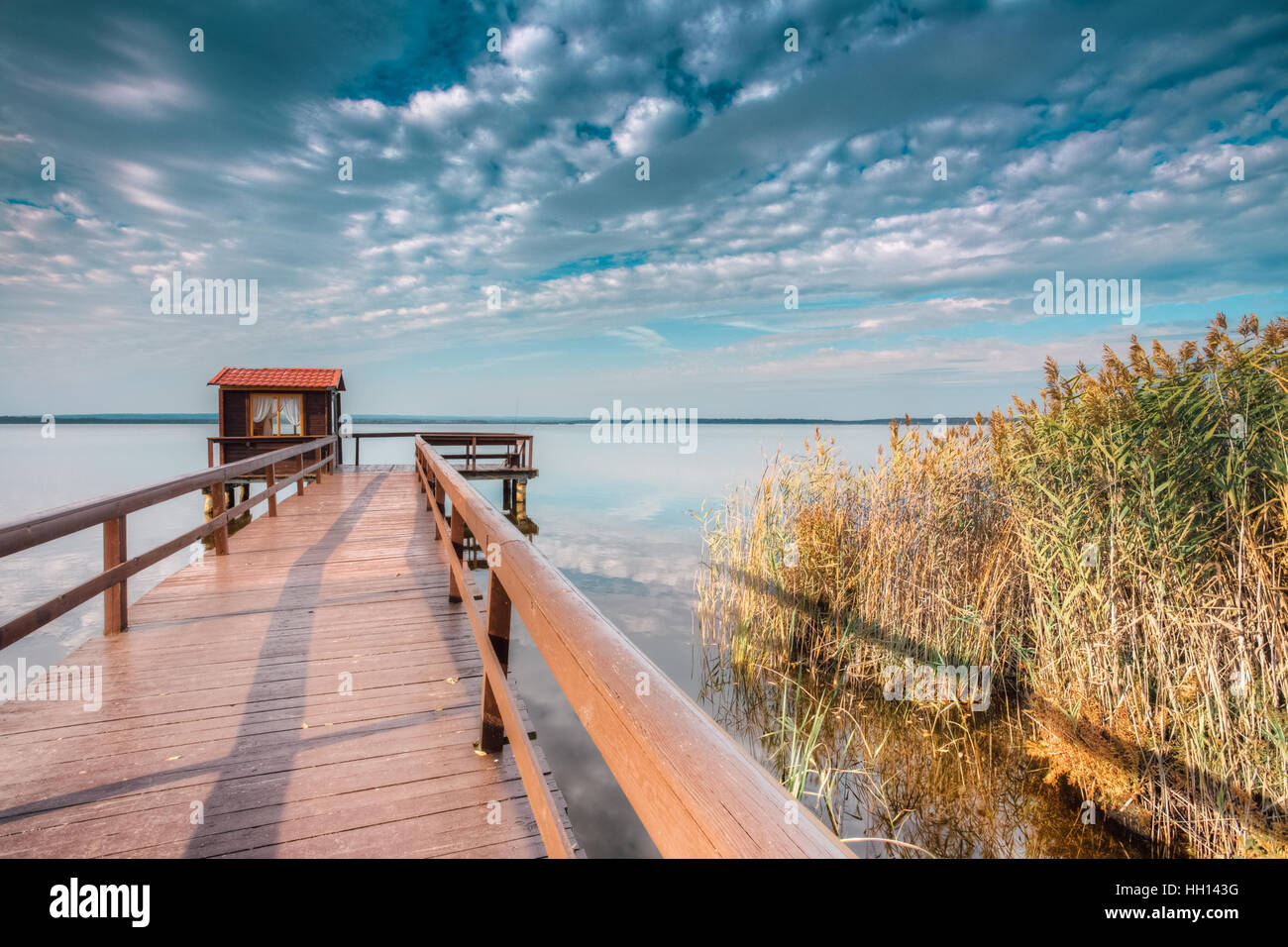 Old wooden pier for fishing, small house shed and beautiful lake or ...