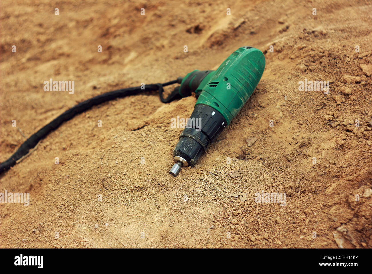 Electric drill on the sand Stock Photo - Alamy