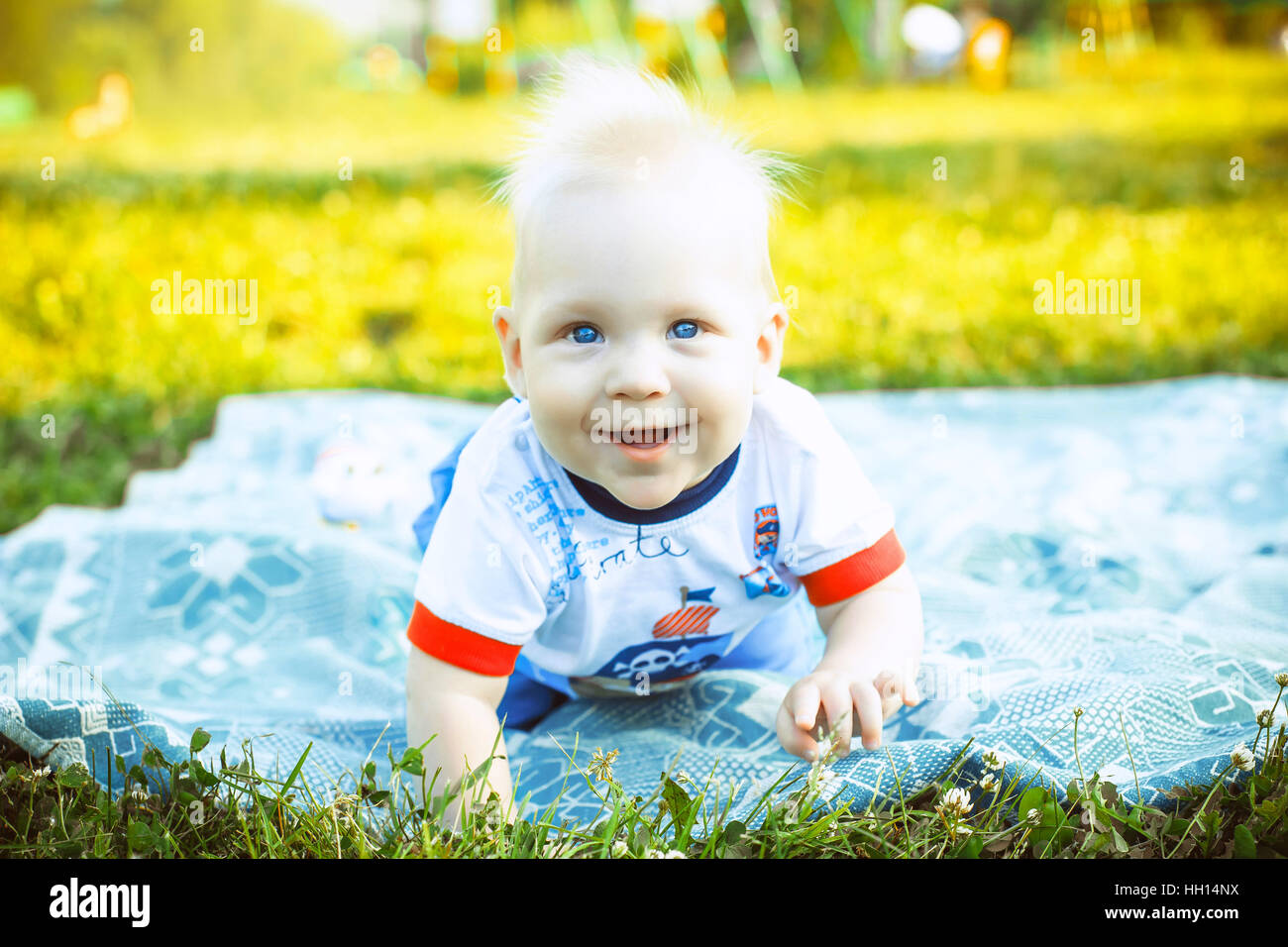 baby smiling and crawling on lawn Stock Photo - Alamy
