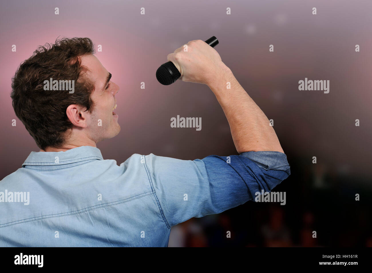 Handsome man singer performing at a concert Stock Photo - Alamy