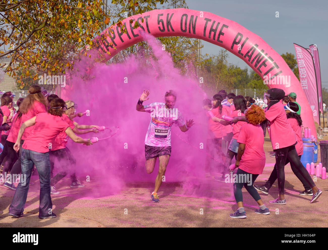 Charity runner is covered with color paints in the London Color Run ...