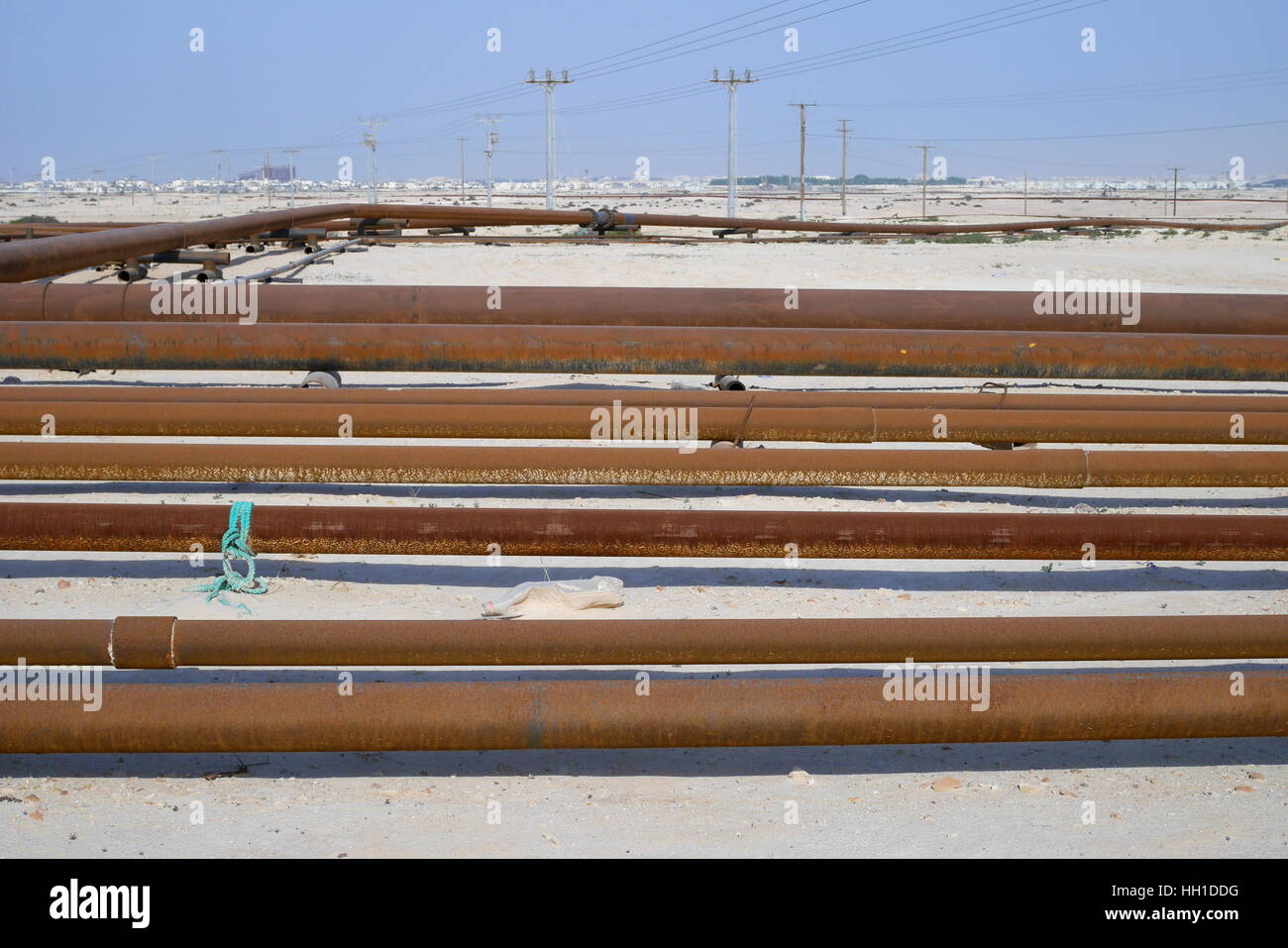 Industrial desert landscape with oil pipelines and electricity pylons ...