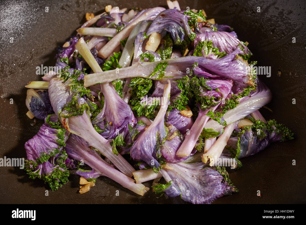 cooked purple kale in a black steel wok Stock Photo - Alamy