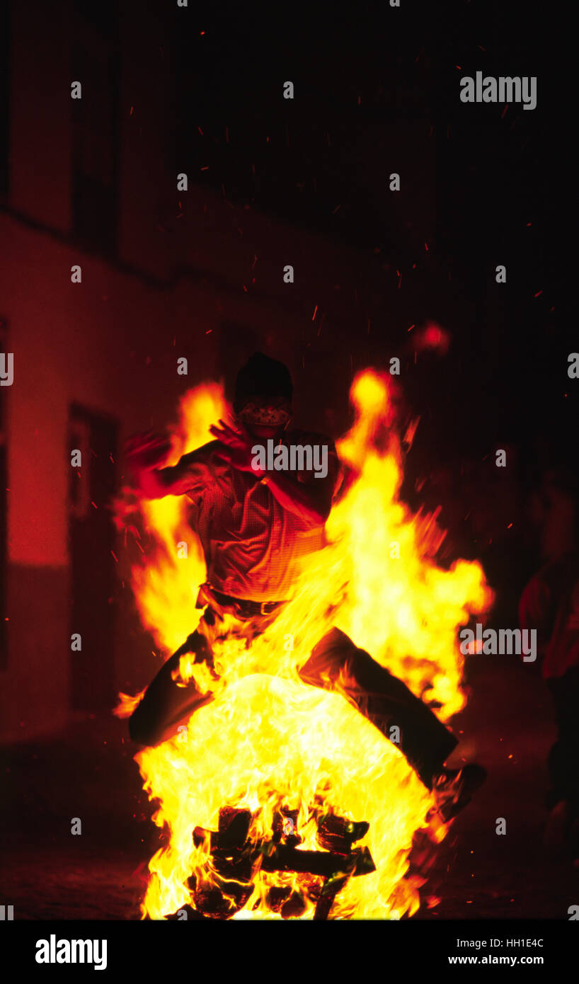 Man is jumping over a fire during the festival (Fiesta) de San Marco in ...