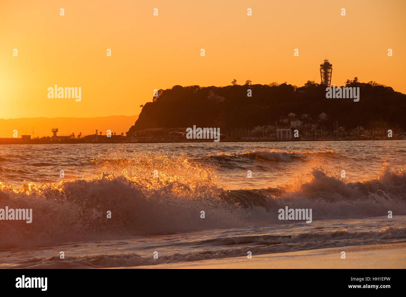 Sunset beach with splash of waves Stock Photo - Alamy