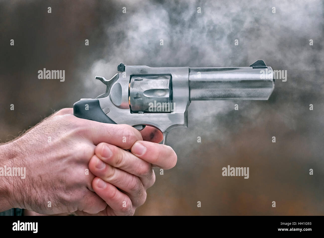 Revolver handgun surrounded with smoke moment after being discharged ...