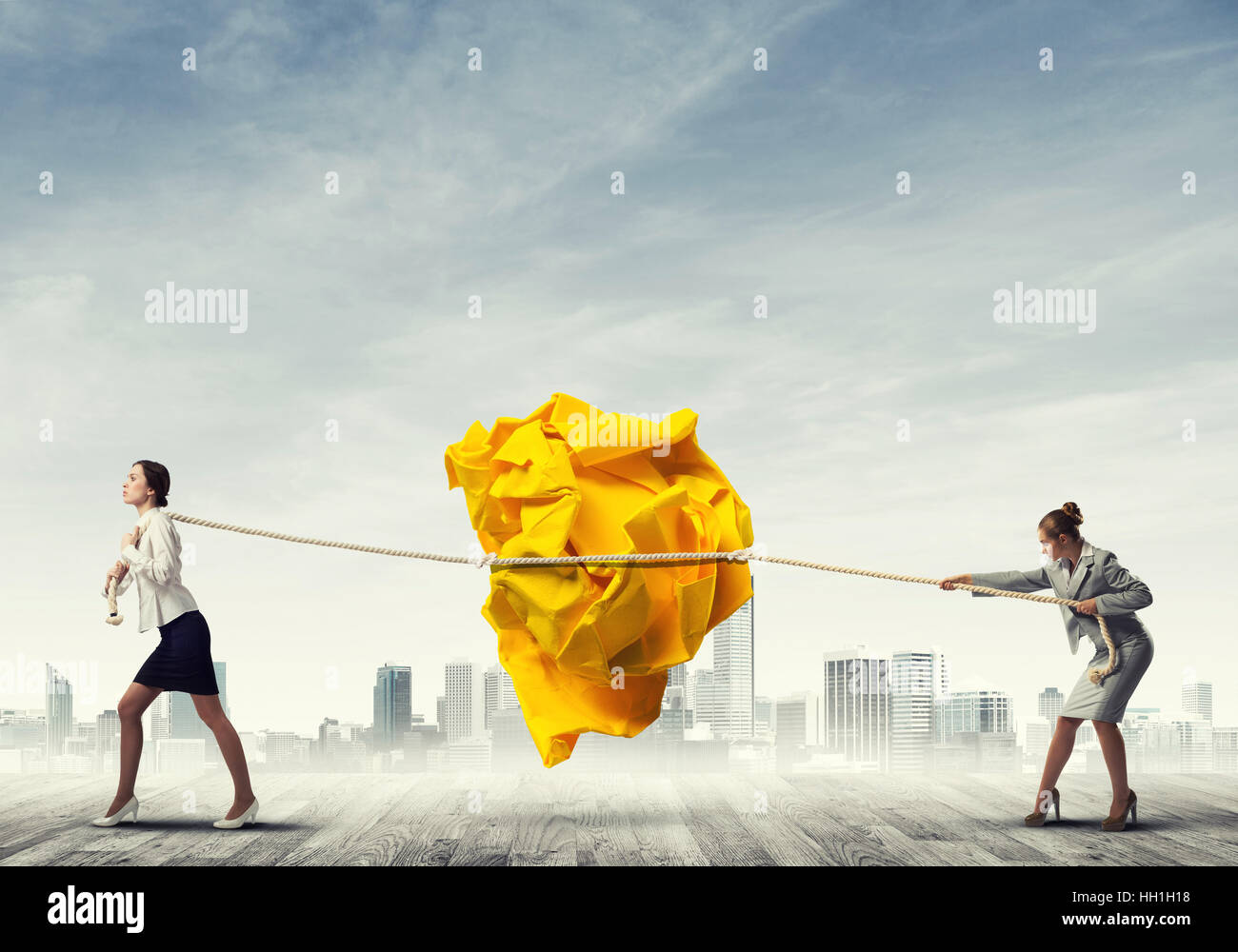 Two women pulling with effort big crumpled ball of paper as creativity ...