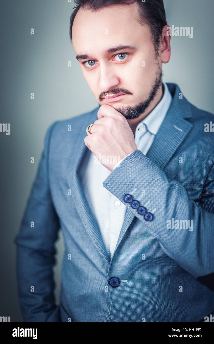 Portrait of a young businessman on grey background Stock Photo - Alamy