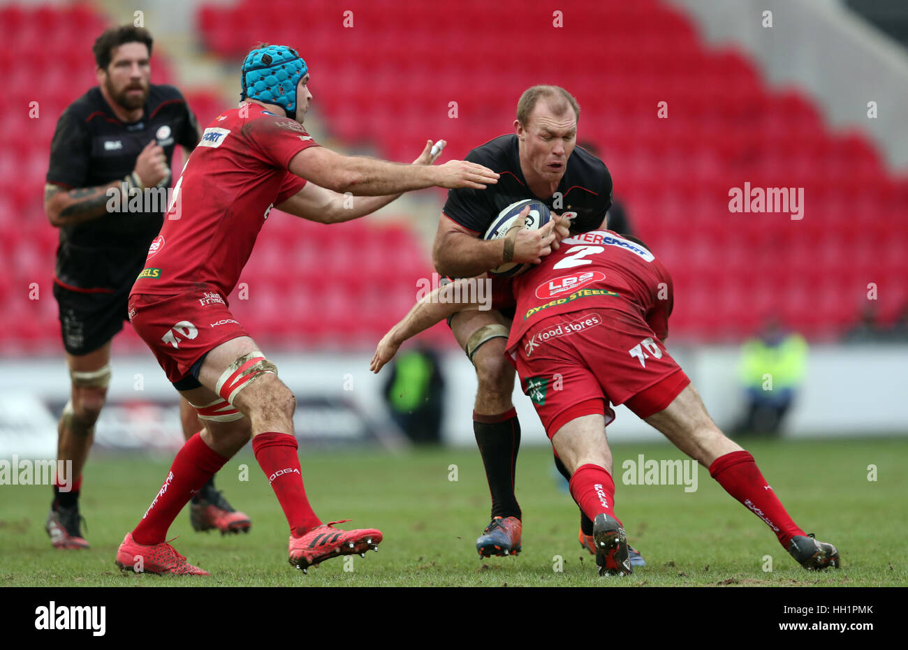 Saracens' Schalk Burger is tackled by Scarlets' Ken Owens and Tadhg ...