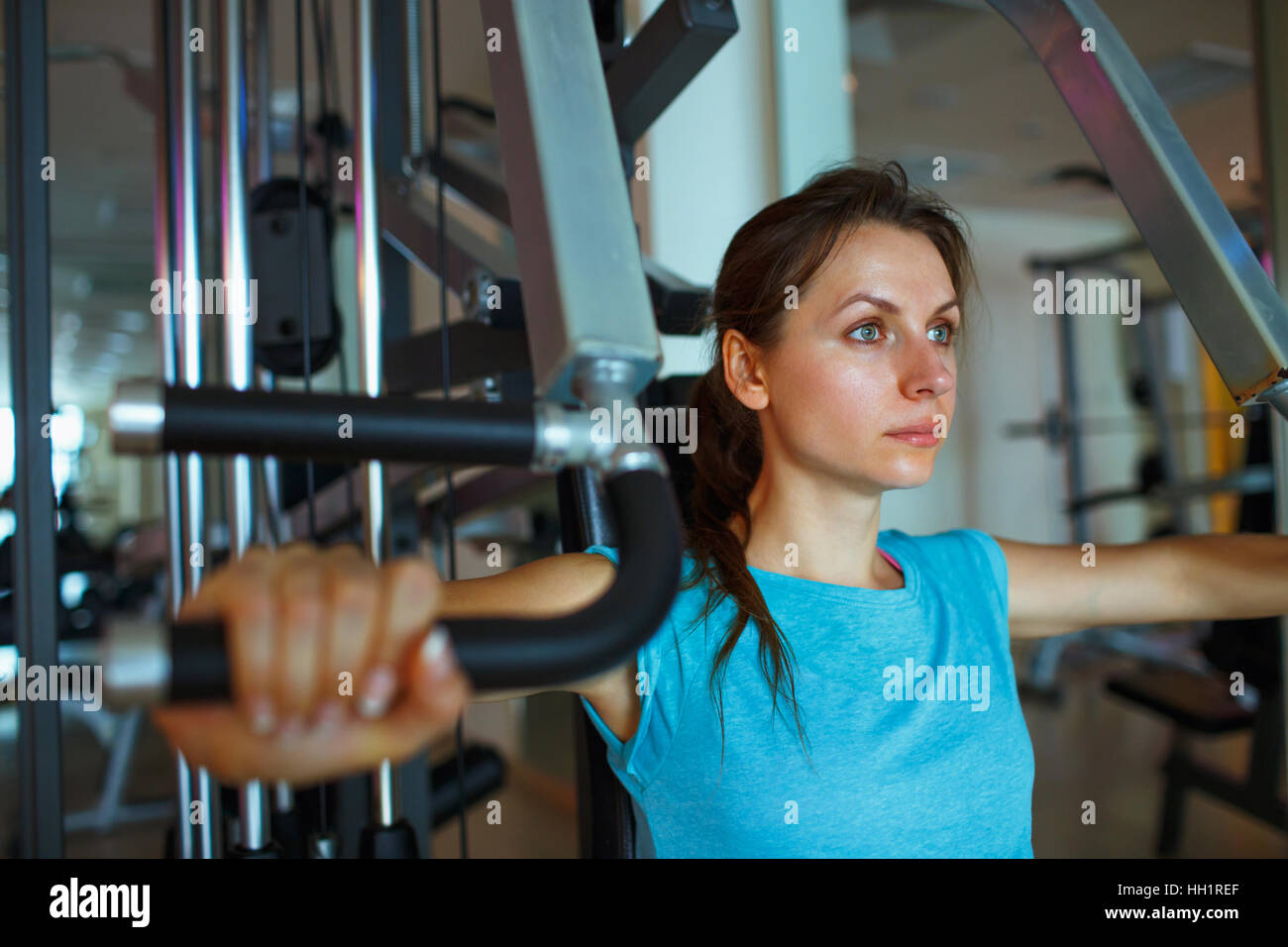 Athletic woman works out on training apparatus in fitness center Stock ...