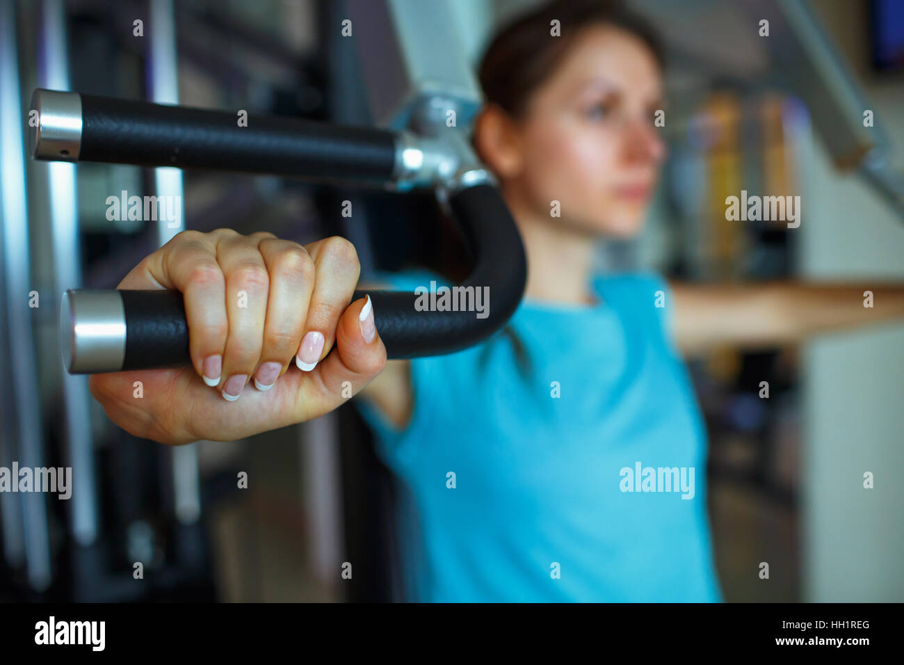 Athletic woman works out on training apparatus in fitness center Stock ...