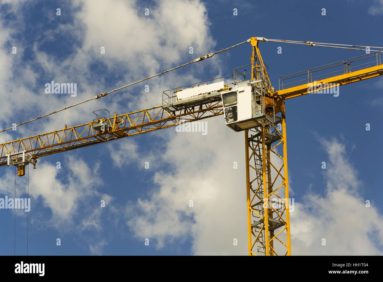 Yellow crane on construction site with blue sky background Stock Photo ...