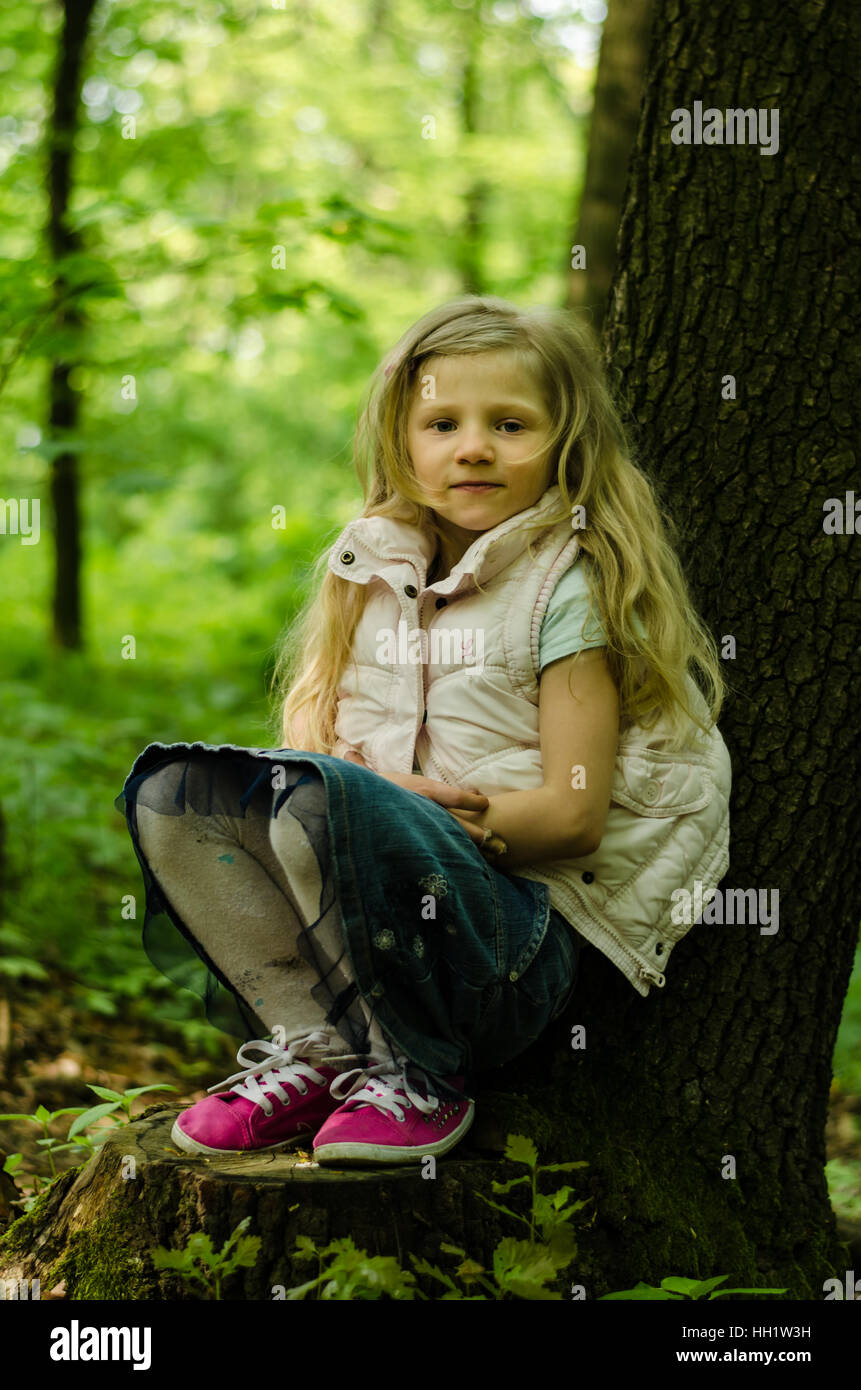 girl with long hair sittig in tree trunk in green spring forest Stock ...