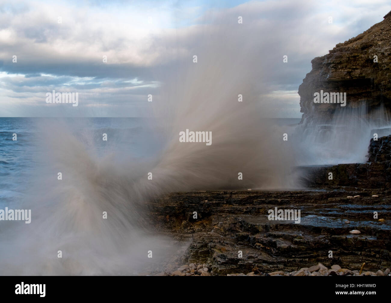 Wave smashing against rocks Stock Photo - Alamy