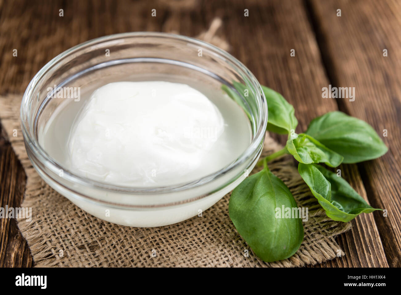 Portion of fresh Mozzarella (close-up shot) on wooden background ...