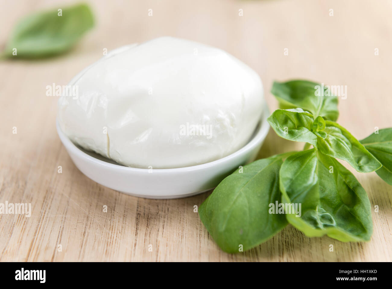 Portion of fresh Mozzarella (close-up shot) on vintage wooden ...