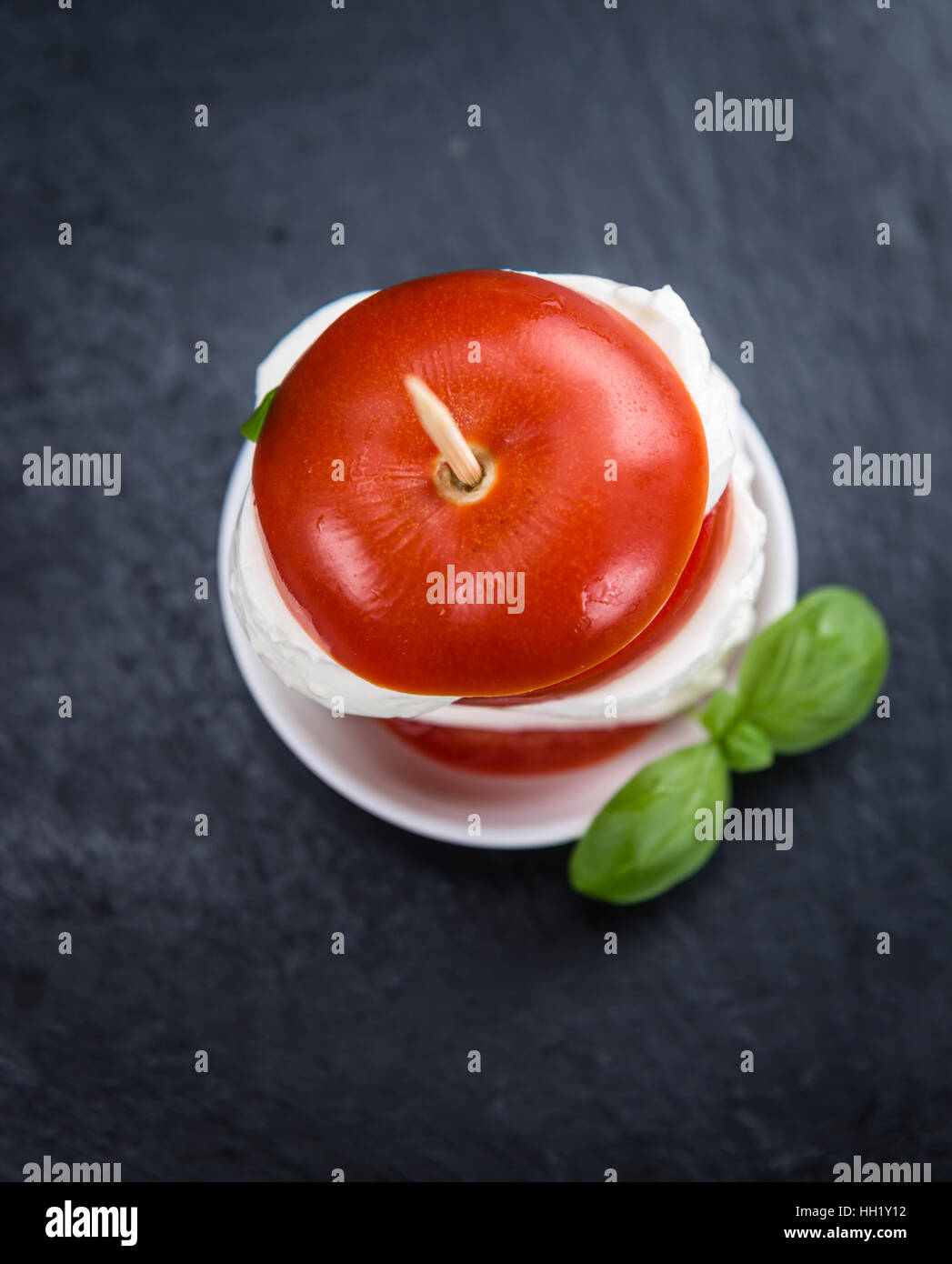 Portion of Mozzarella with Tomatoes (detailed close-up shot; selective ...