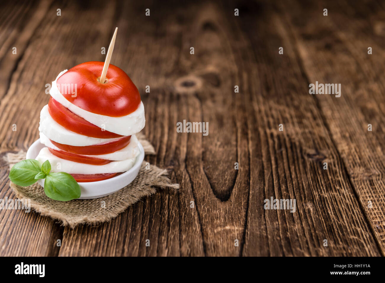 Portion of Mozzarella with Tomatoes (detailed close-up shot; selective ...