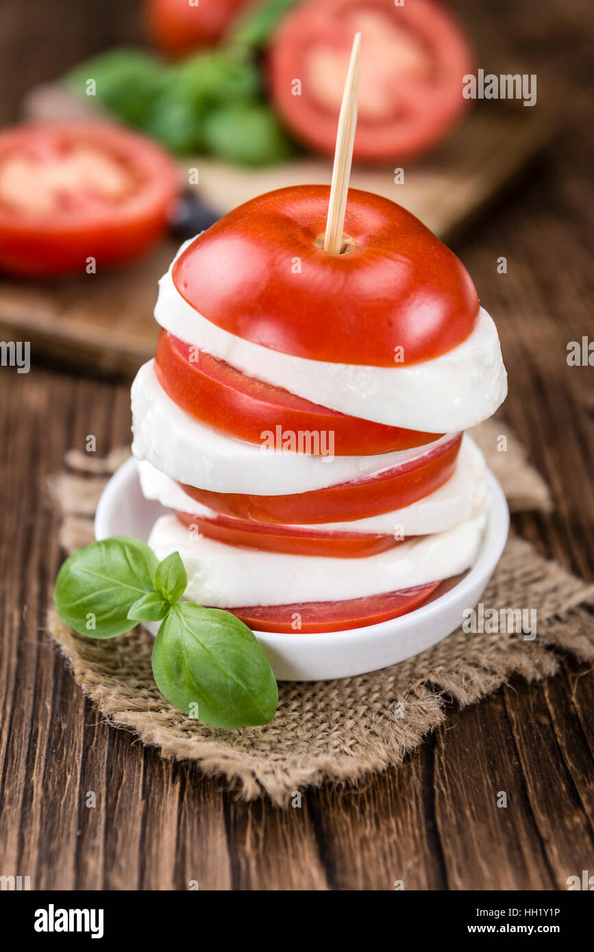 Portion of Mozzarella with Tomatoes (detailed close-up shot; selective ...
