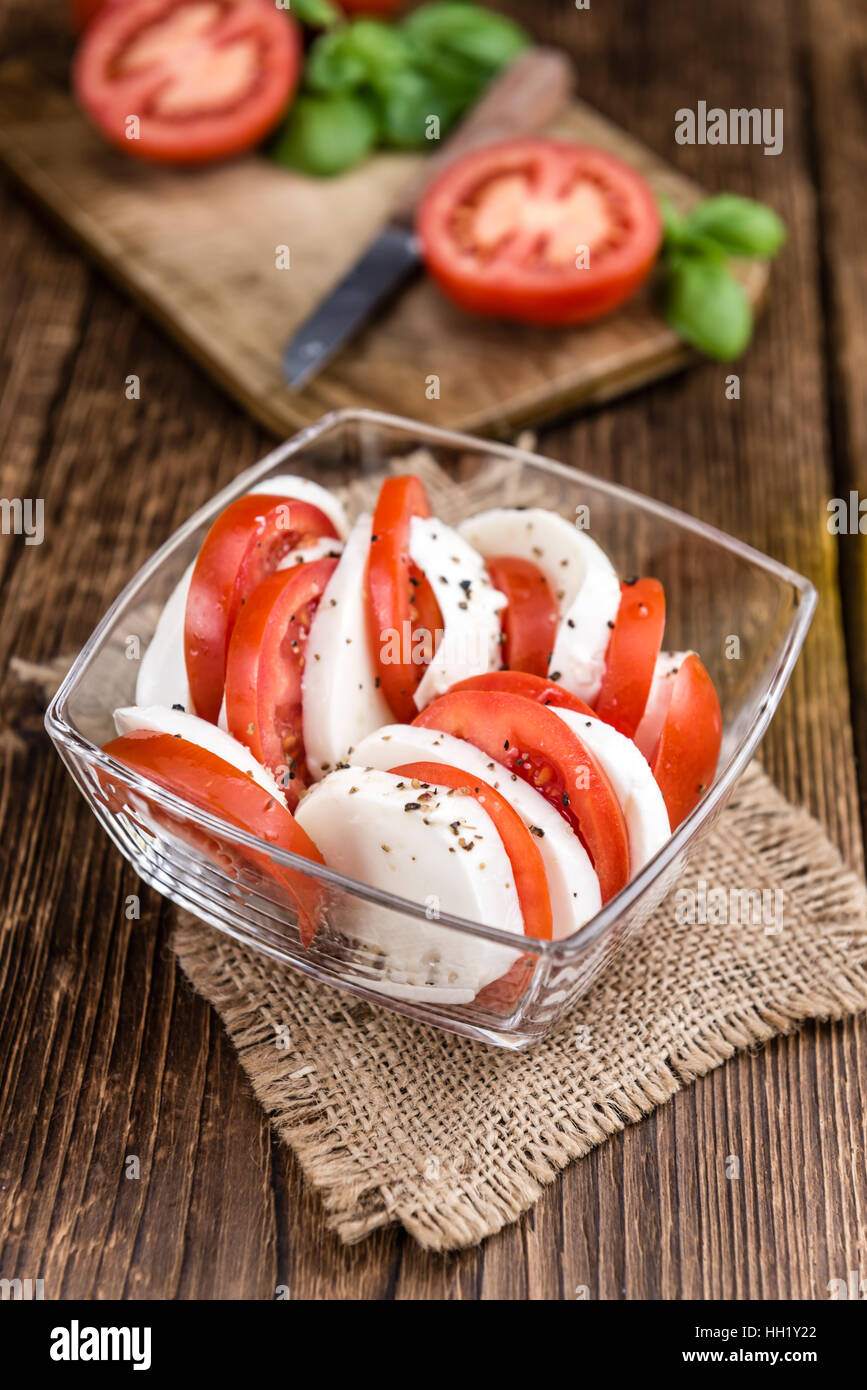 Portion of Mozzarella with Tomatoes (detailed close-up shot; selective ...