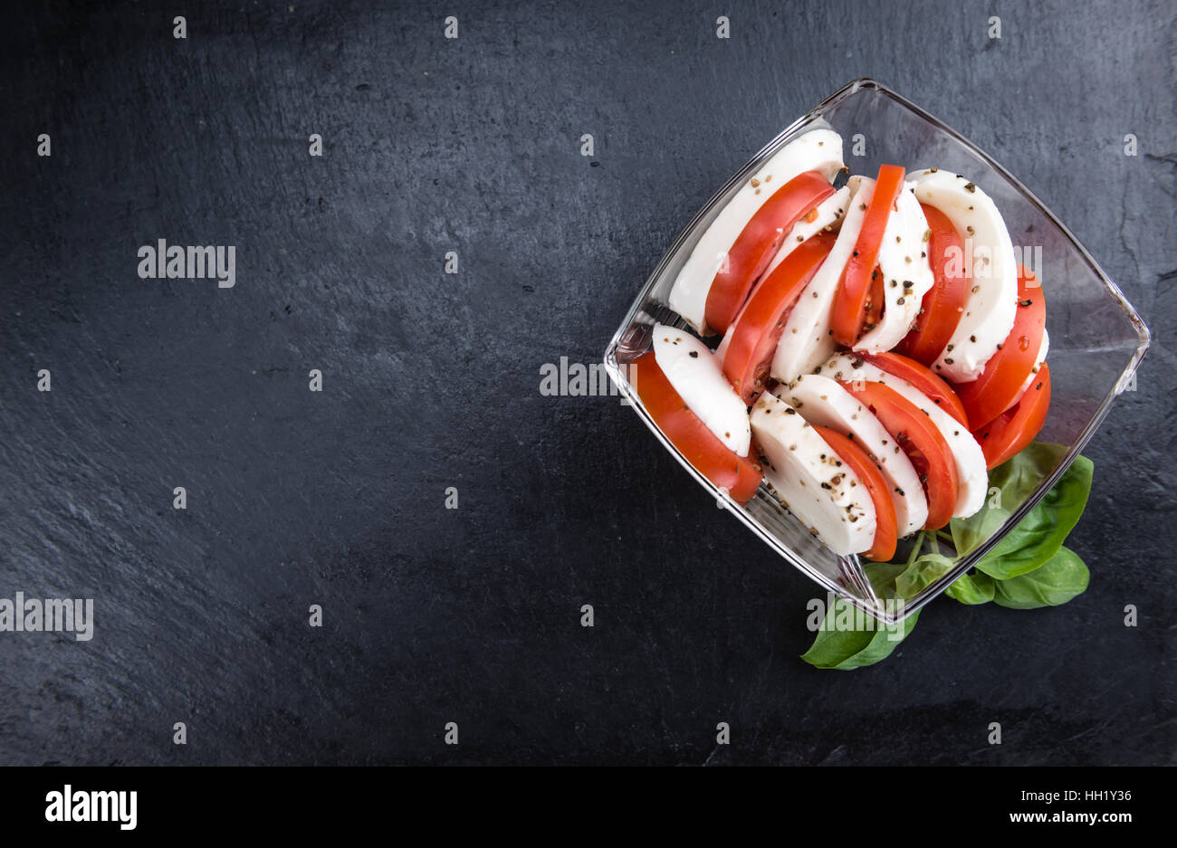 Portion of Mozzarella with Tomatoes (detailed close-up shot; selective ...