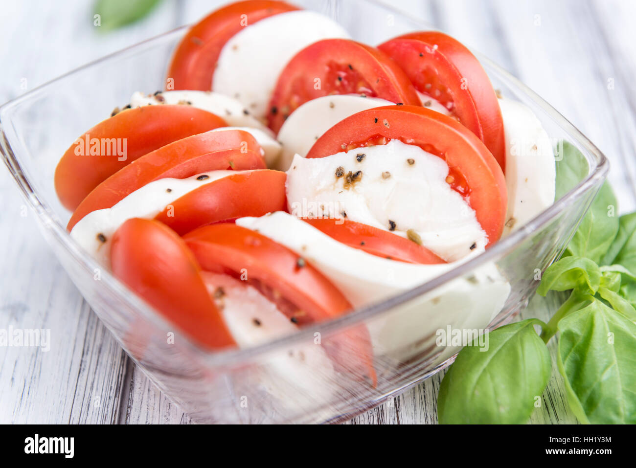 Portion of Mozzarella with Tomatoes (detailed close-up shot; selective ...