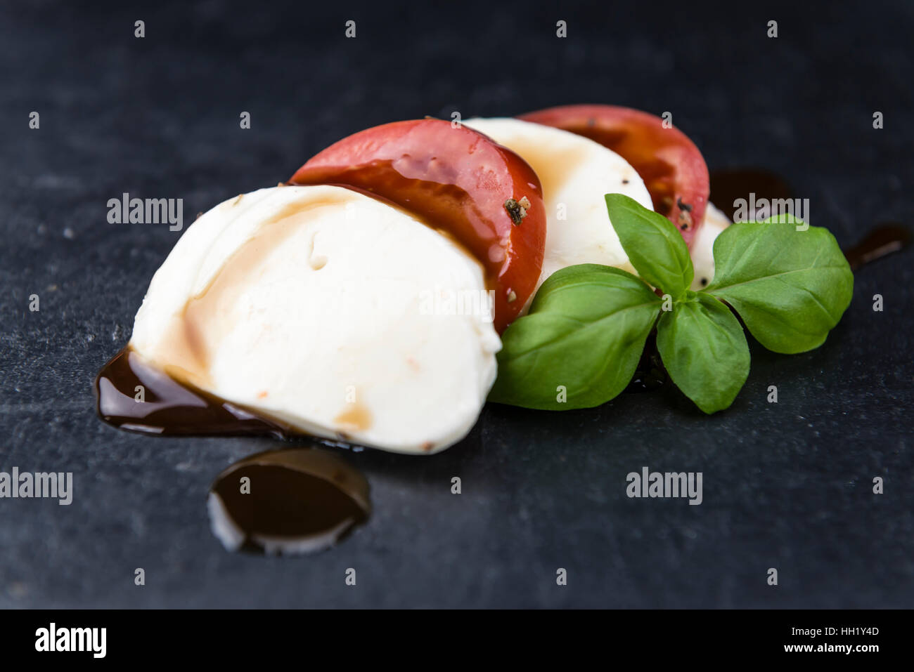 Portion of Mozzarella with Tomatoes (detailed close-up shot; selective ...