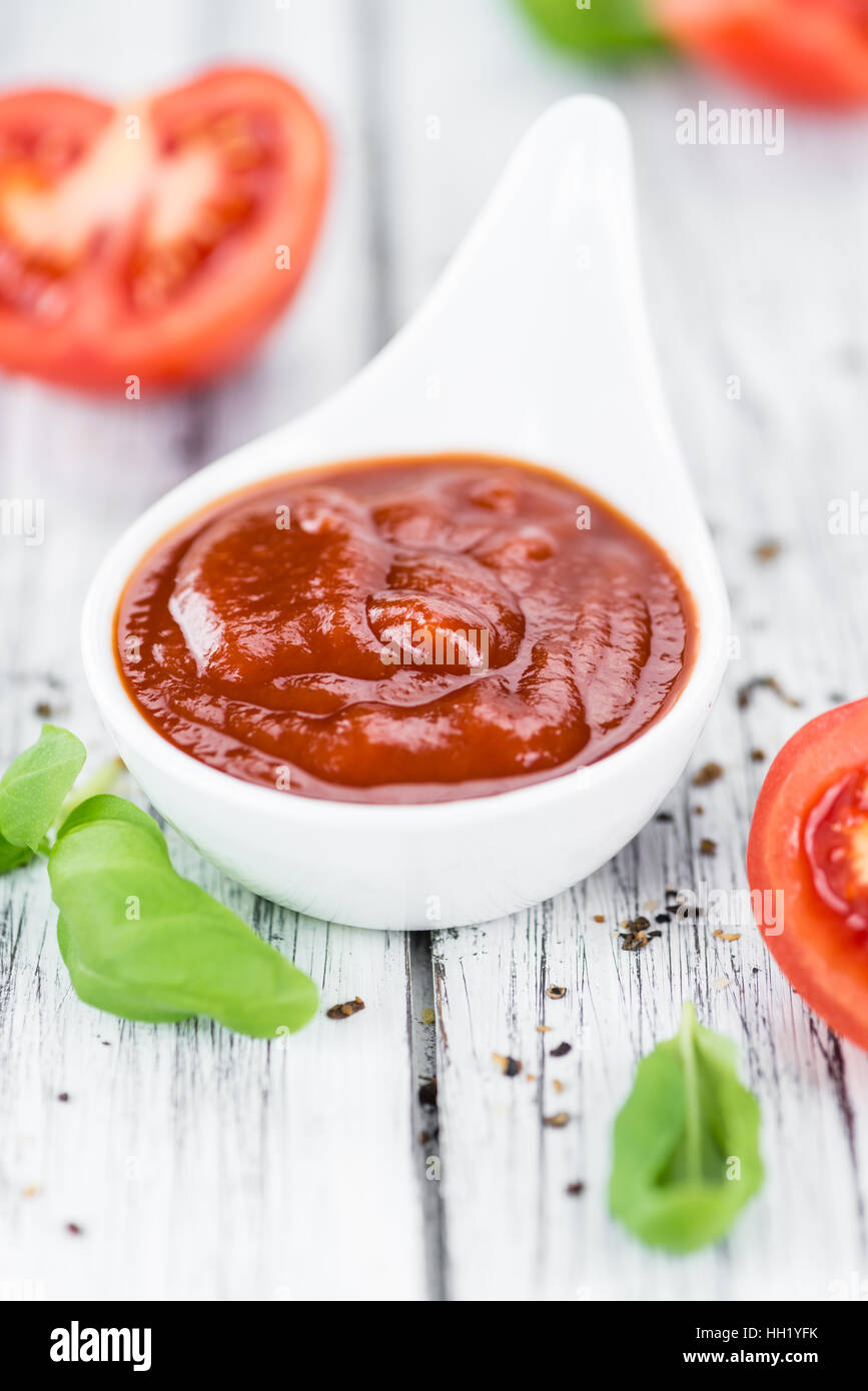 Tomato Ketchup on an old wooden table as detailed close-up shot ...
