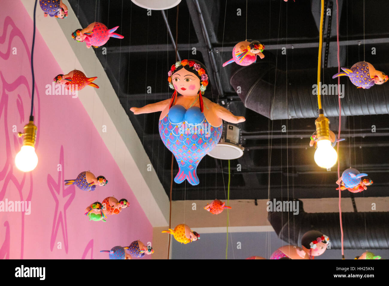 Photograph of some toy fat mermaids hanging,from the roof Stock Photo ...