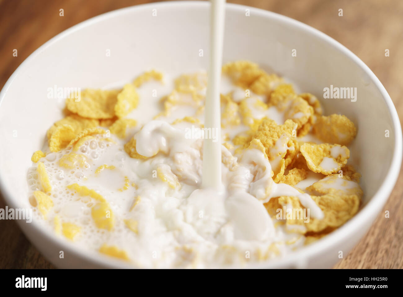 milk pour into bowl with corn flakes Stock Photo - Alamy