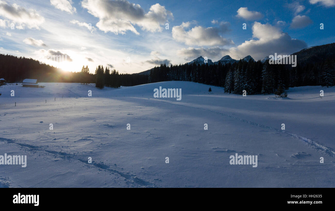 Sun rising above snow covered meadow Stock Photo - Alamy