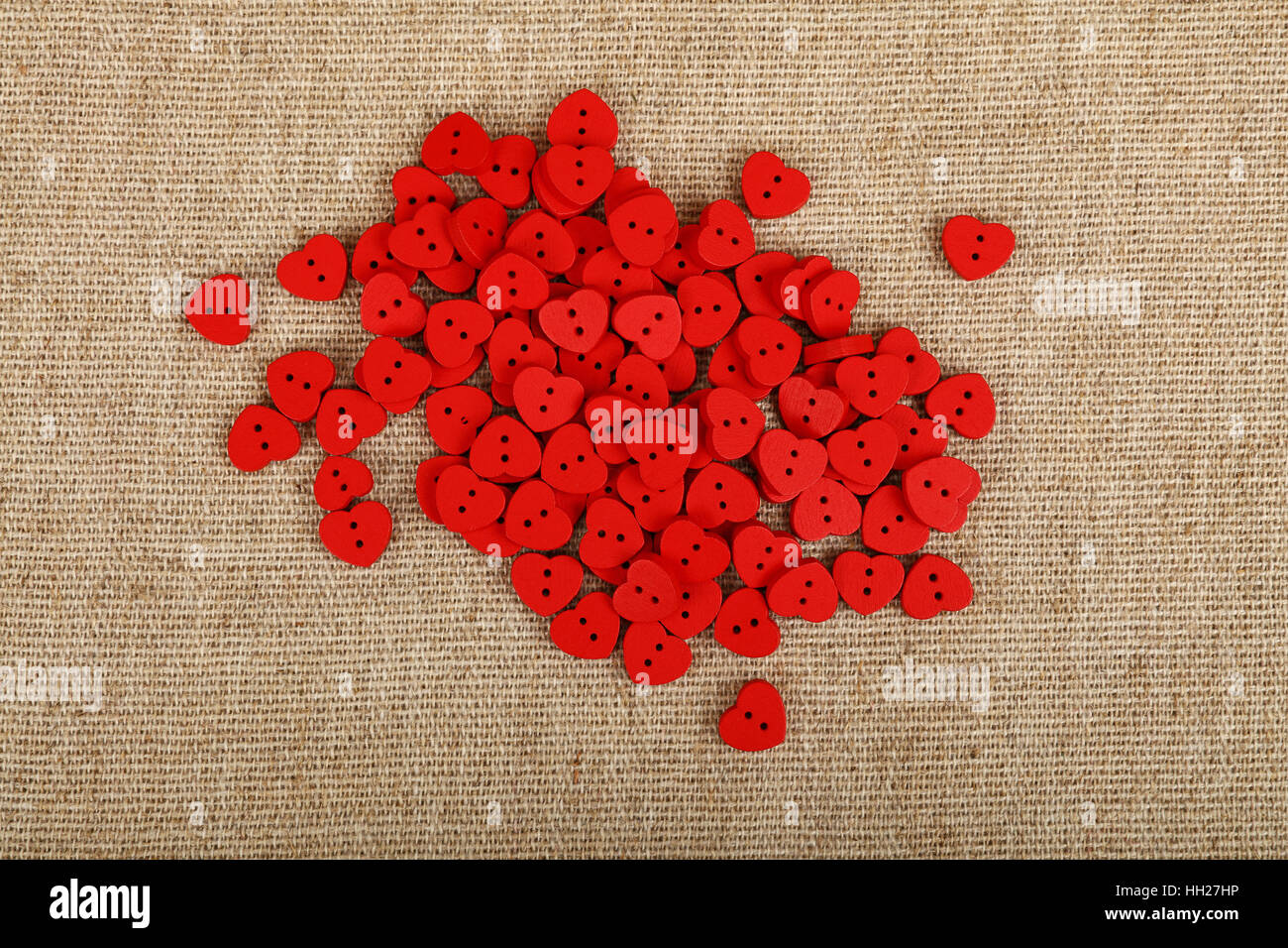 Red heart shaped handmade wooden sewing buttons on linen canvas ...